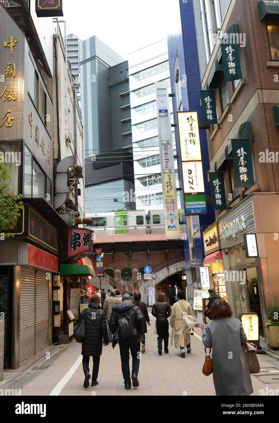 The busy narrow street around the elevated JR track in Shimbashin and ...