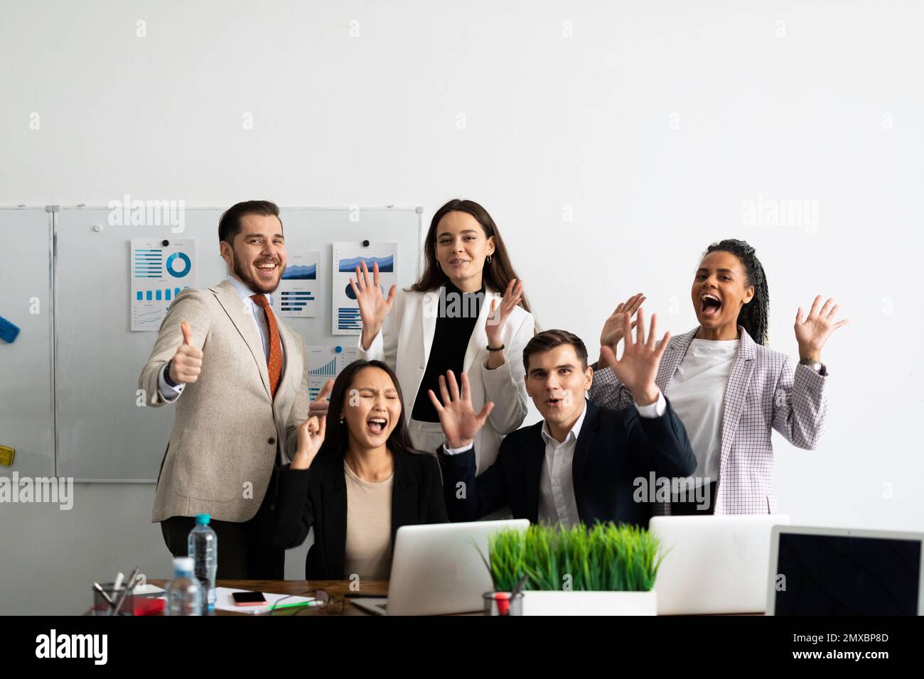 a group of businessmen colleagues standing in the office at laptops ...