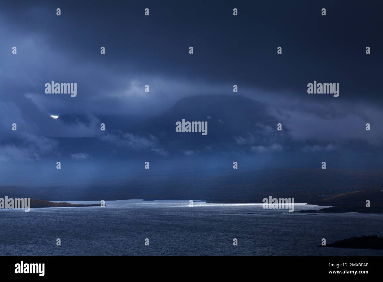 Cloudscape, nightfall in the Lapland mountains. Lake on this side and ...
