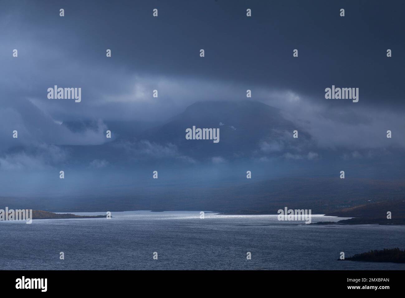 Cloudscape, nightfall in the Lapland mountains. Lake on this side and ...