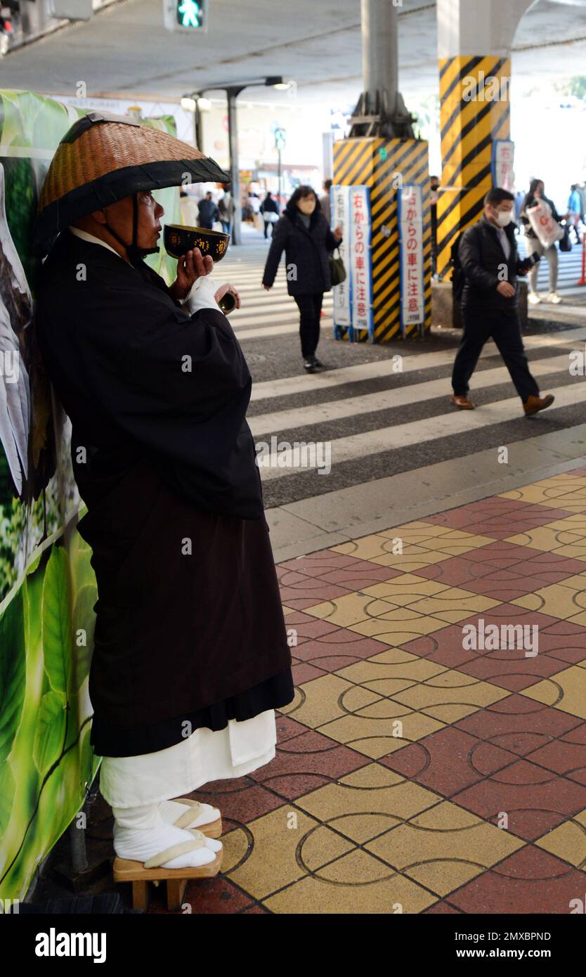 A Japanese Zen monk collecting alms outside the Ueno station in Tokyo ...