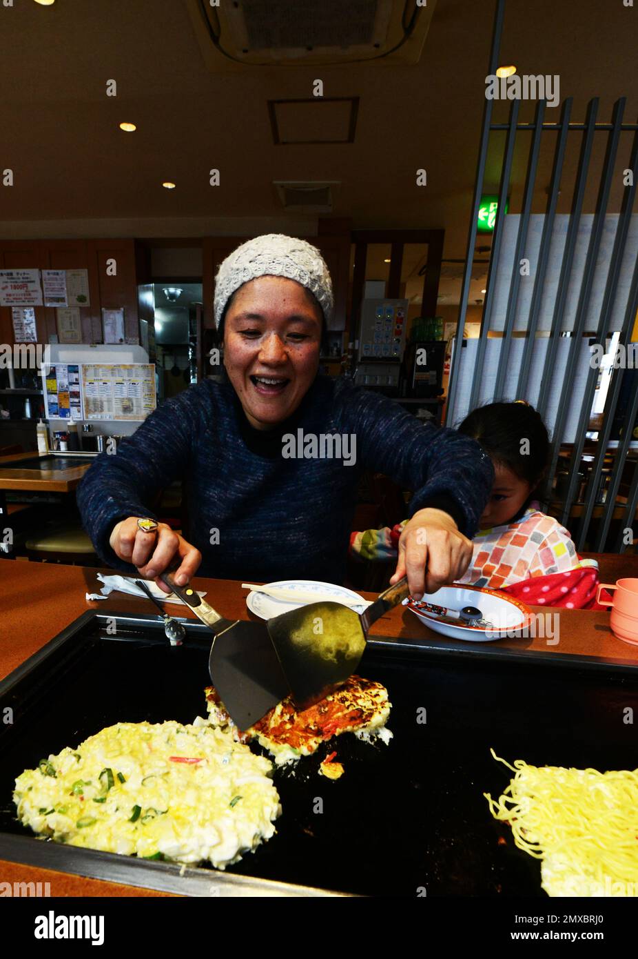 A Japanese woman cooking Okonomiyaki on a teppan Stock Photo - Alamy