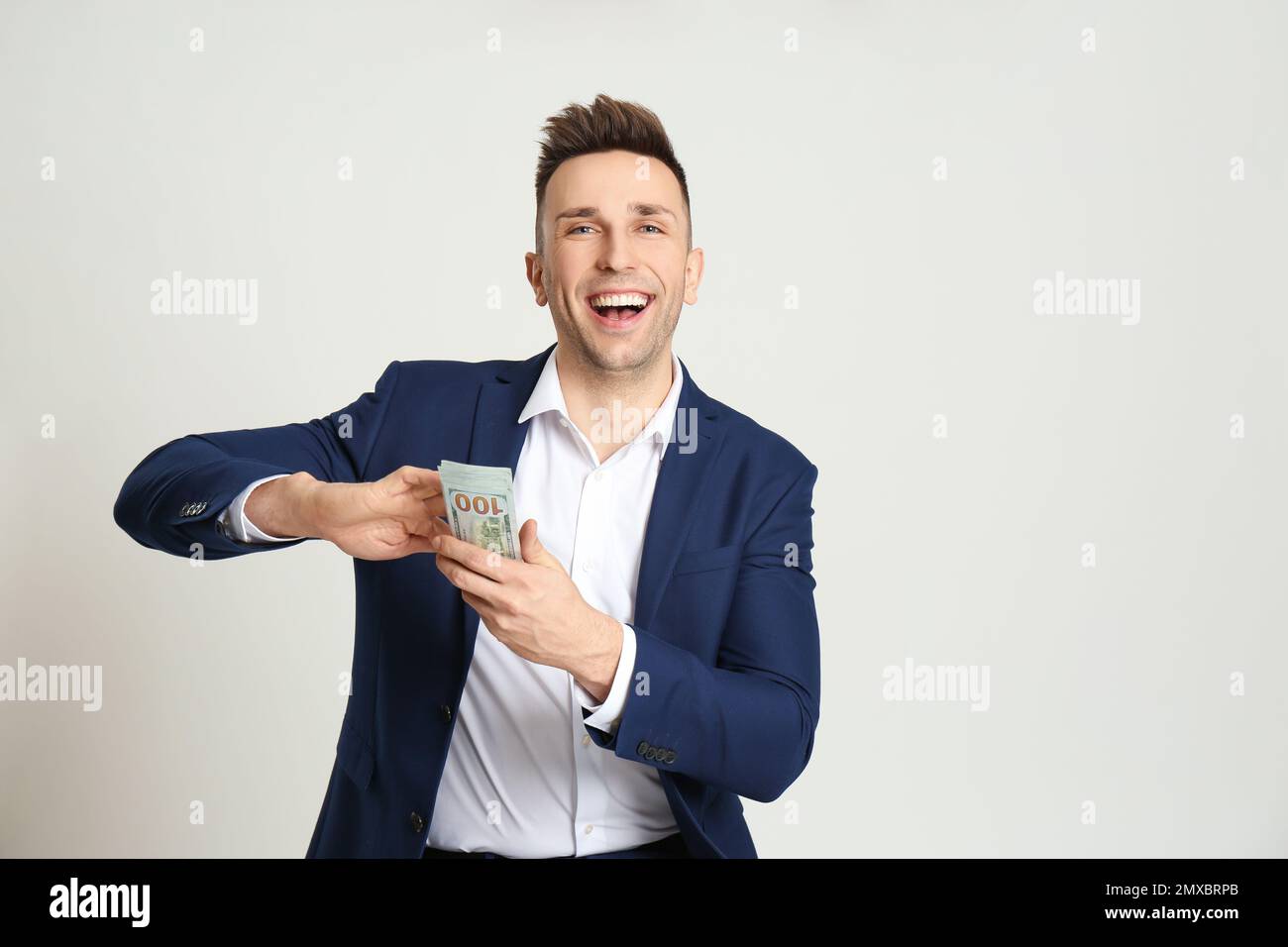 Happy man throwing money on light grey background. Space for text Stock ...
