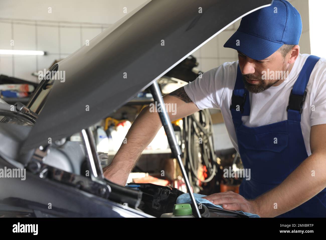 Professional auto mechanic fixing modern car in service center Stock ...