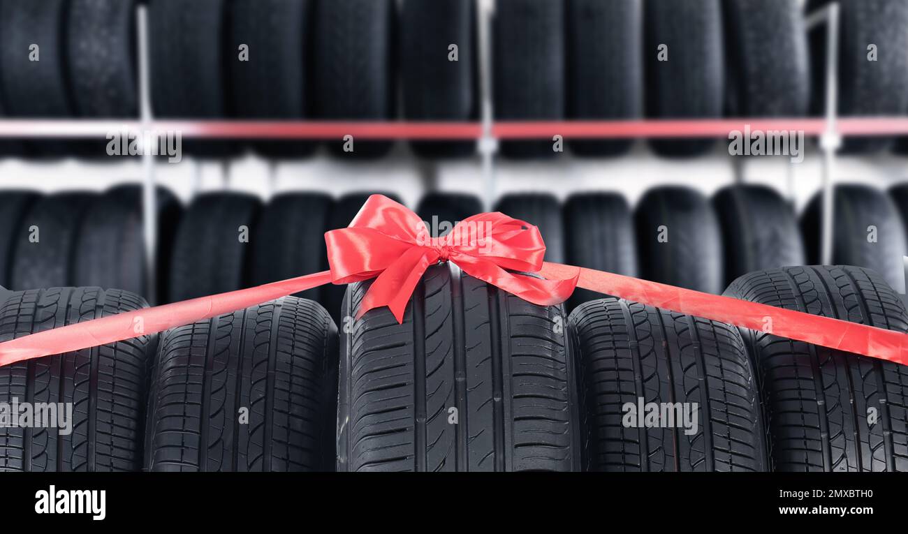 Car tires tied with red ribbon in auto store. Banner design Stock Photo ...