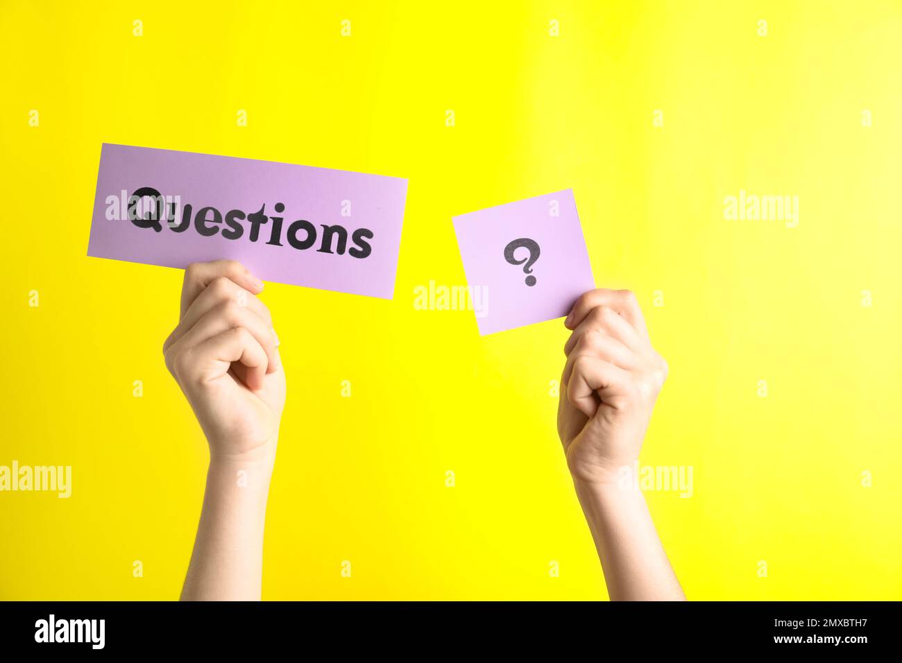Woman holding sheets of paper with word QUESTIONS and query mark on ...