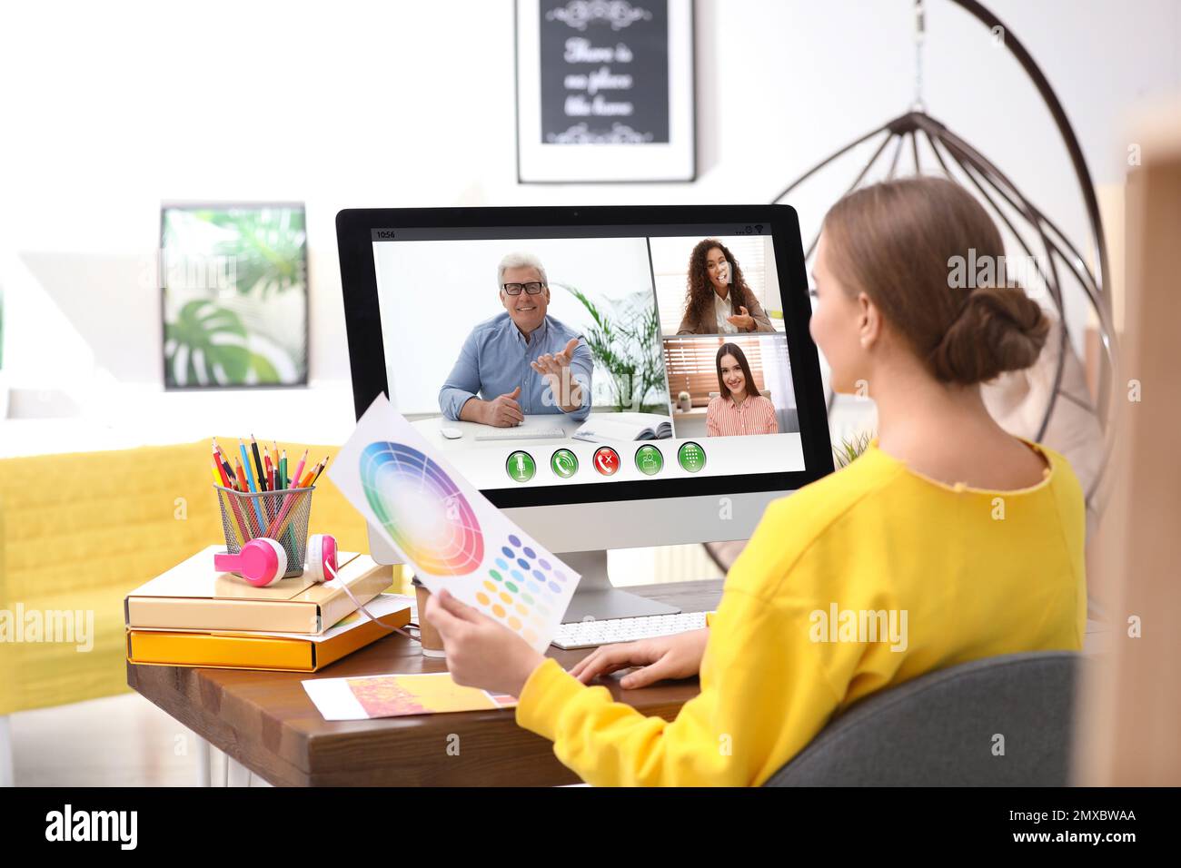 Woman having video chat with colleagues at table in office. Team work ...
