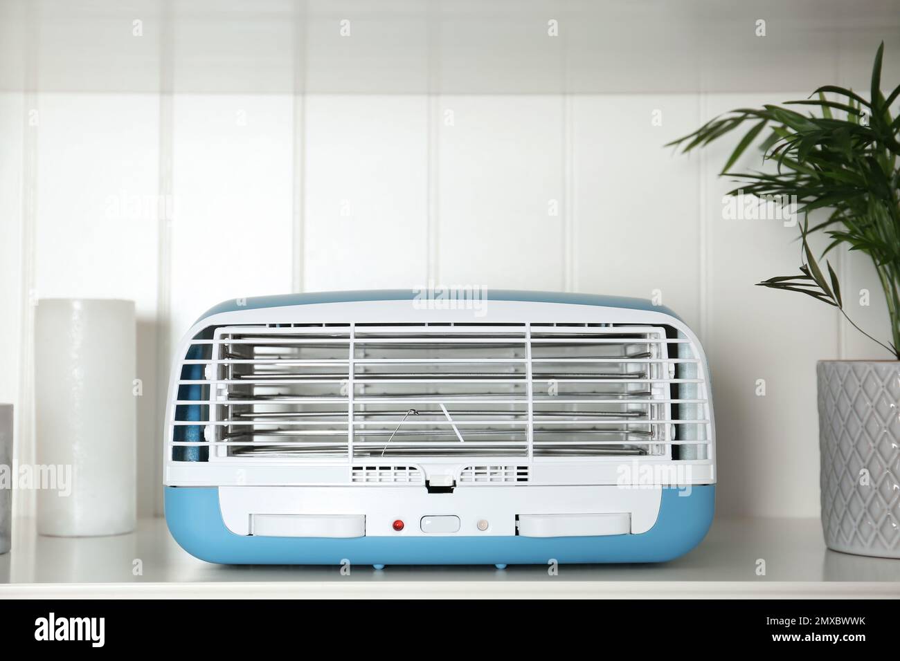 Modern air purifier on white wooden shelf Stock Photo - Alamy