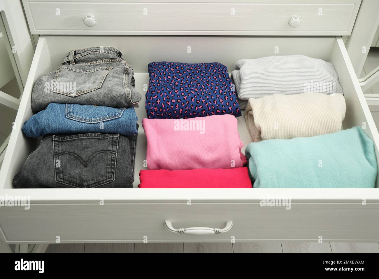 Folded clothes in open drawer. Apparel storage Stock Photo - Alamy