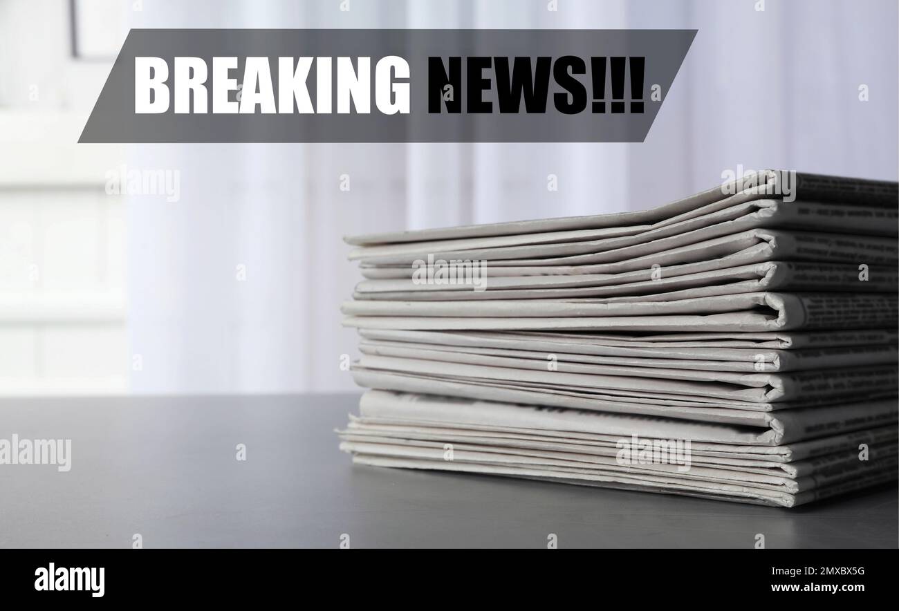 Phrase Breaking News stack of newspapers on grey table. Journalist's ...