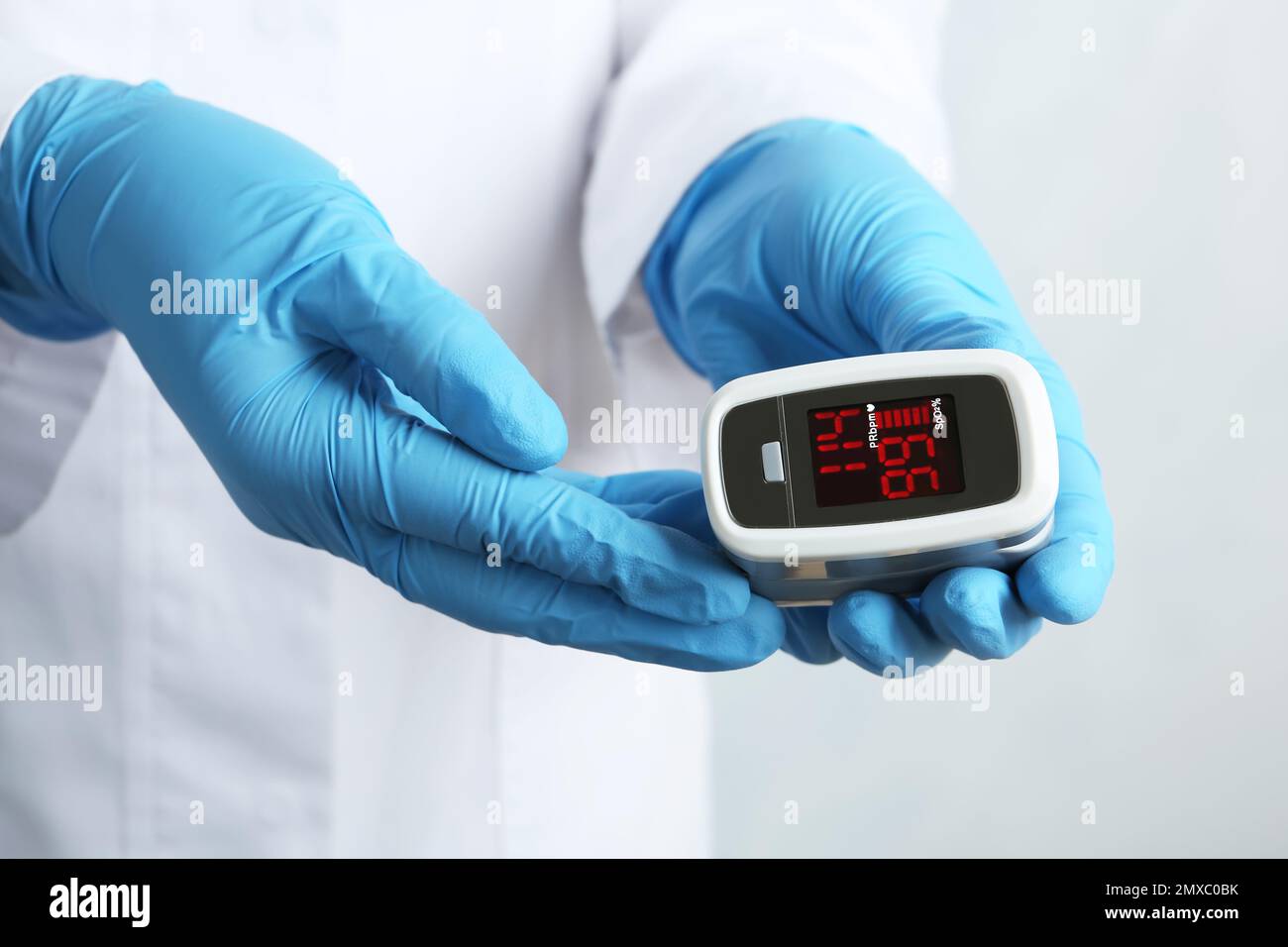 Doctor holding modern fingertip pulse oximeter, closeup Stock Photo - Alamy
