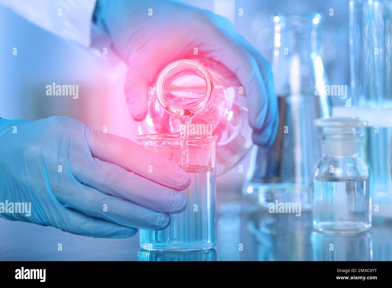 Scientist pouring liquid into beaker at table, closeup. Laboratory ...