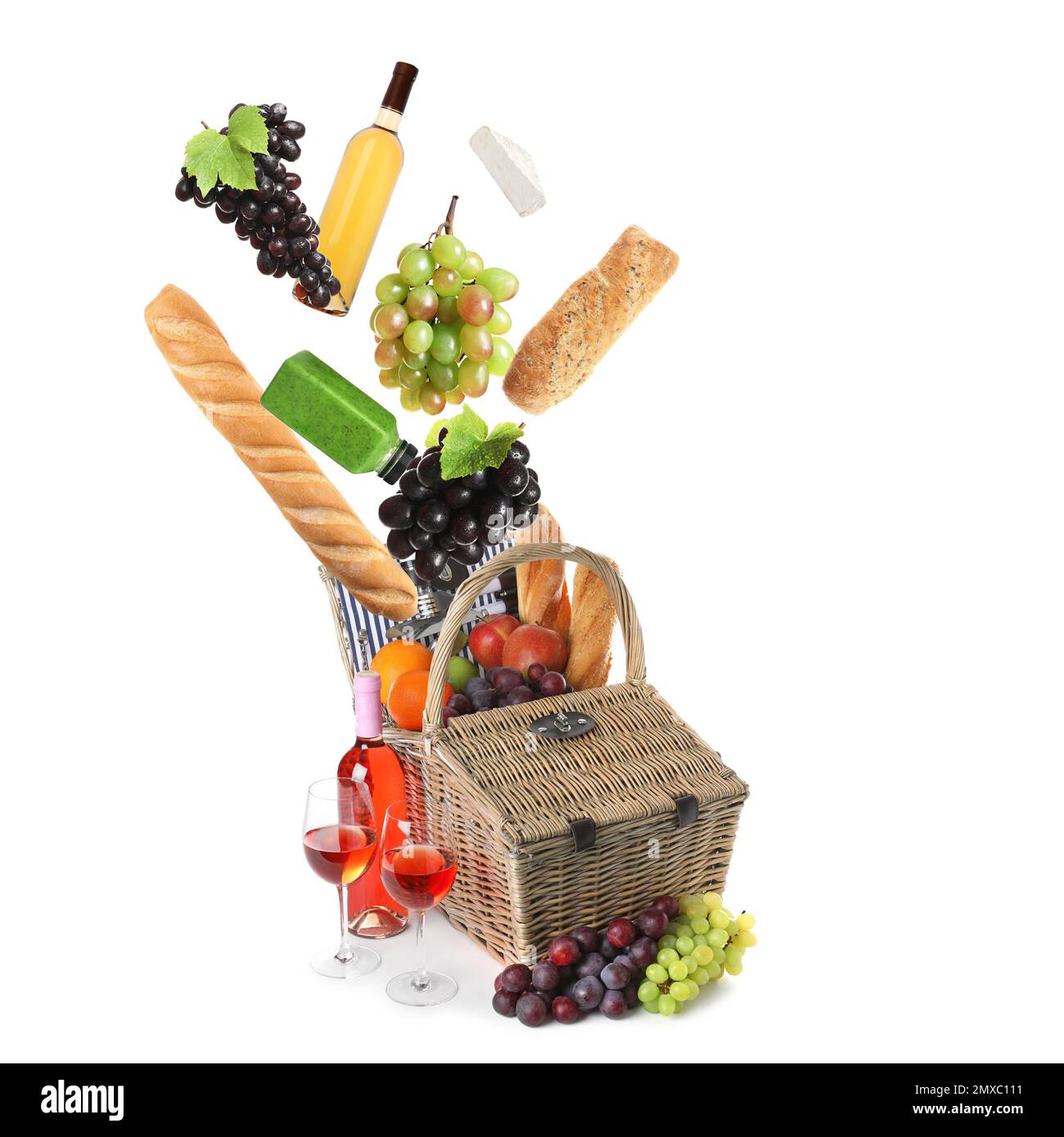 Different products falling in picnic basket on white background Stock ...