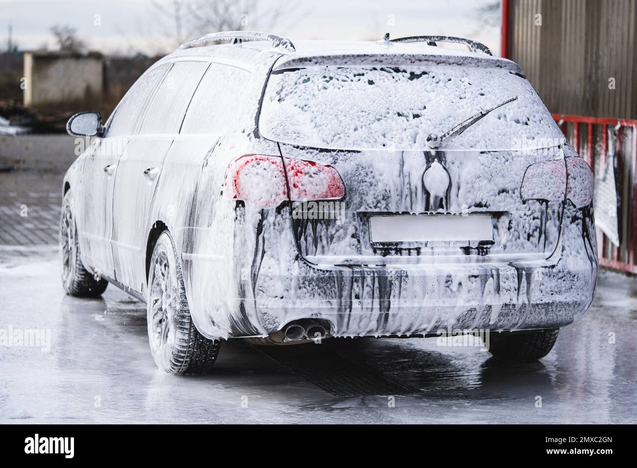 the car at the car wash is covered with foam, wash under pressure with ...