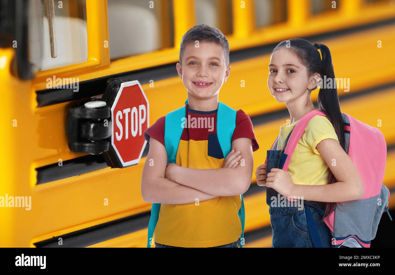 Children with backpacks near yellow school bus. Transport for students ...