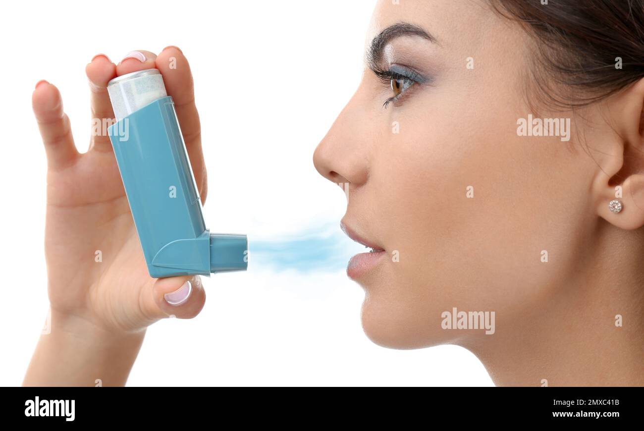 Young woman using asthma inhaler on white background, closeup Stock ...