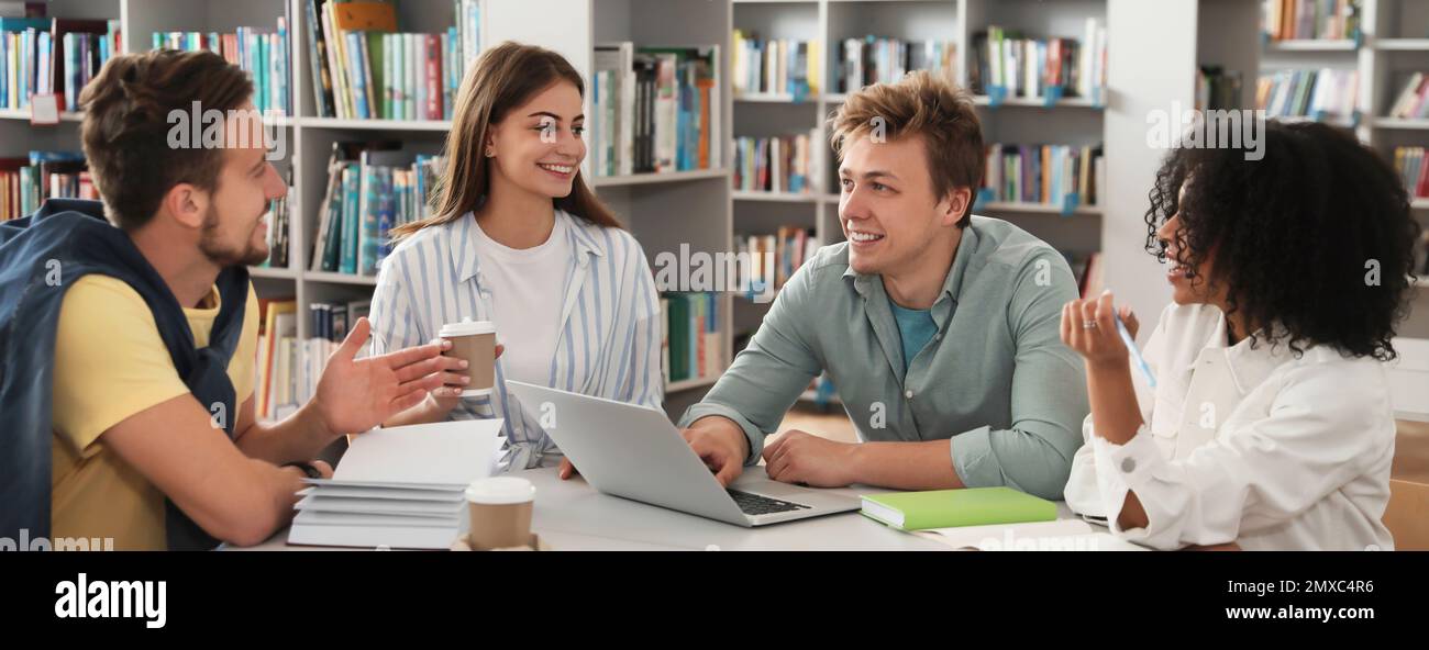 Group of young students at table in library. Banner design Stock Photo ...