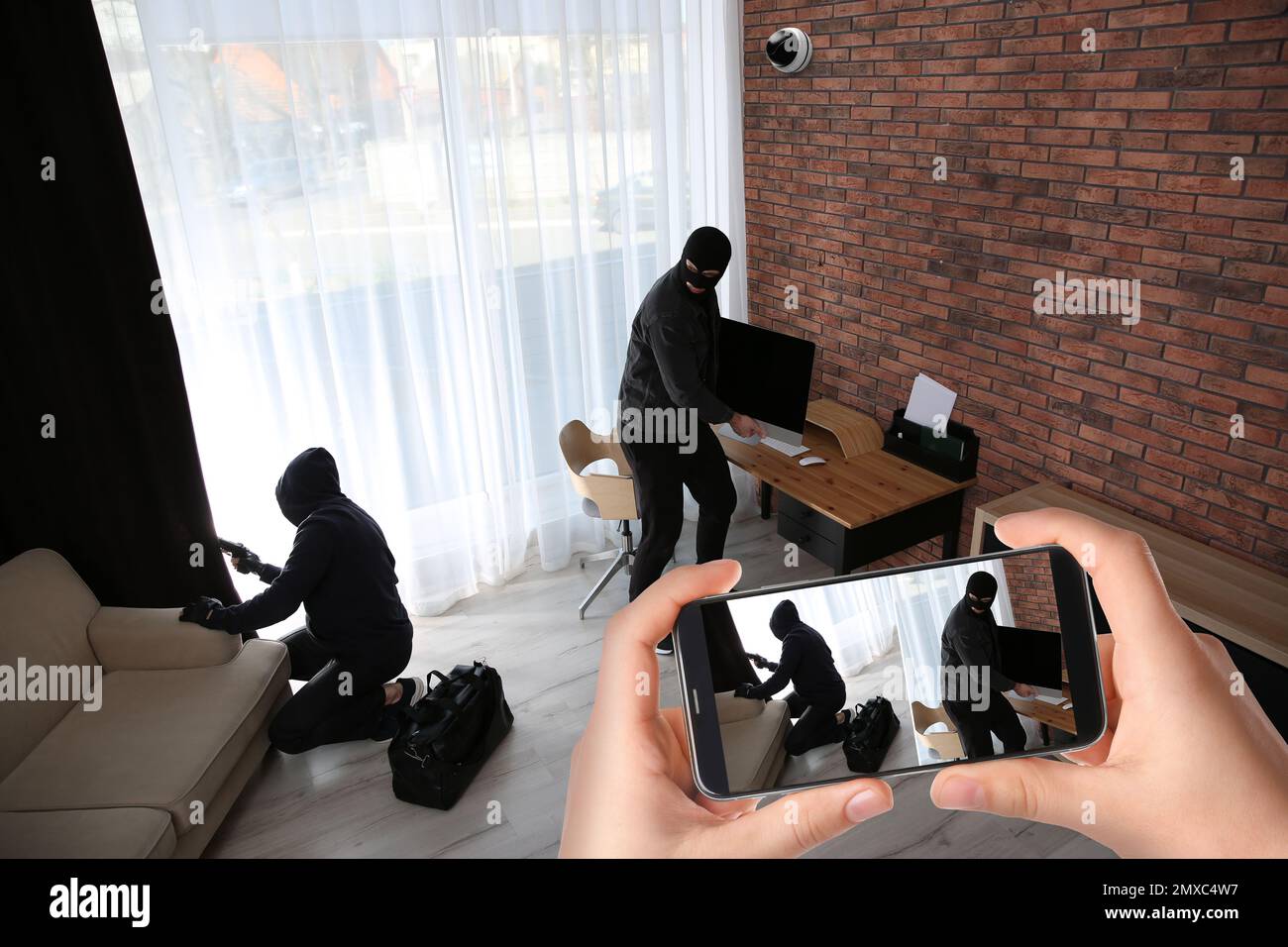 Man monitoring situation at his house with CCTV app on smartphone ...