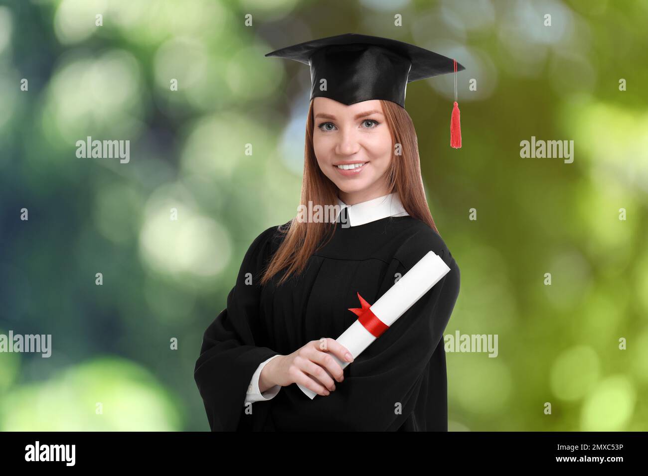 Happy student with graduation hat and diploma on blurred background ...