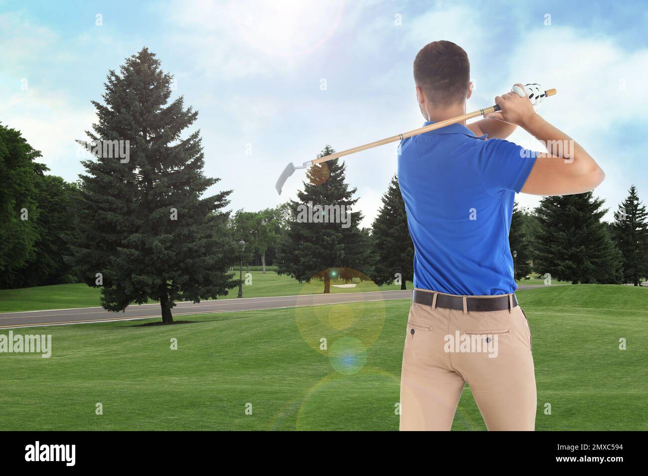 Young man playing golf on course with green grass, back view. Space for ...
