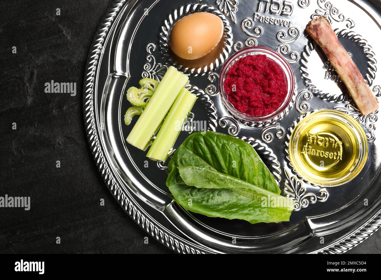 Passover Seder plate (keara) on black table, top view. Pesah ...