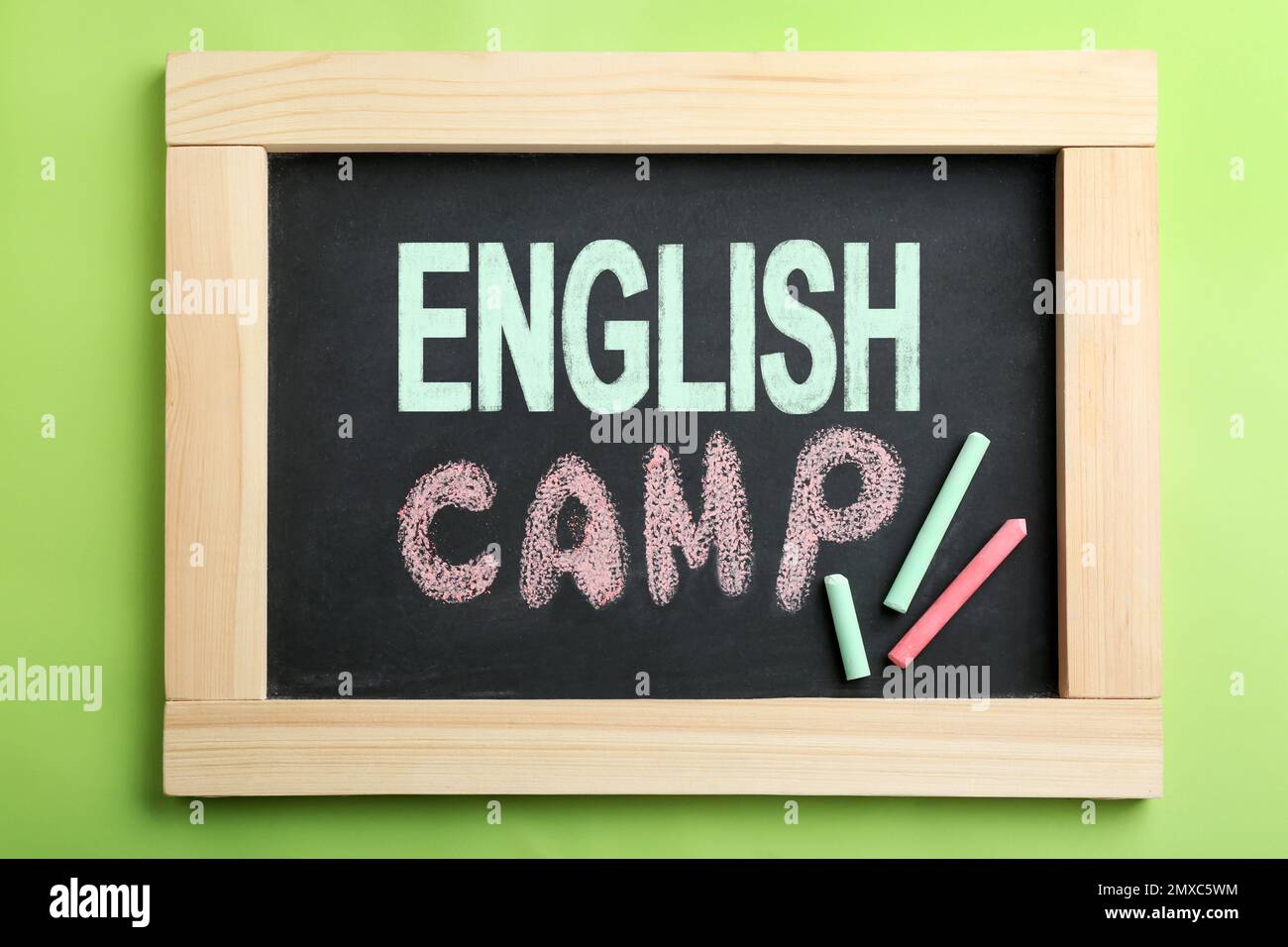 Words ENGLISH CAMP on small blackboard and colorful chalk, top view ...
