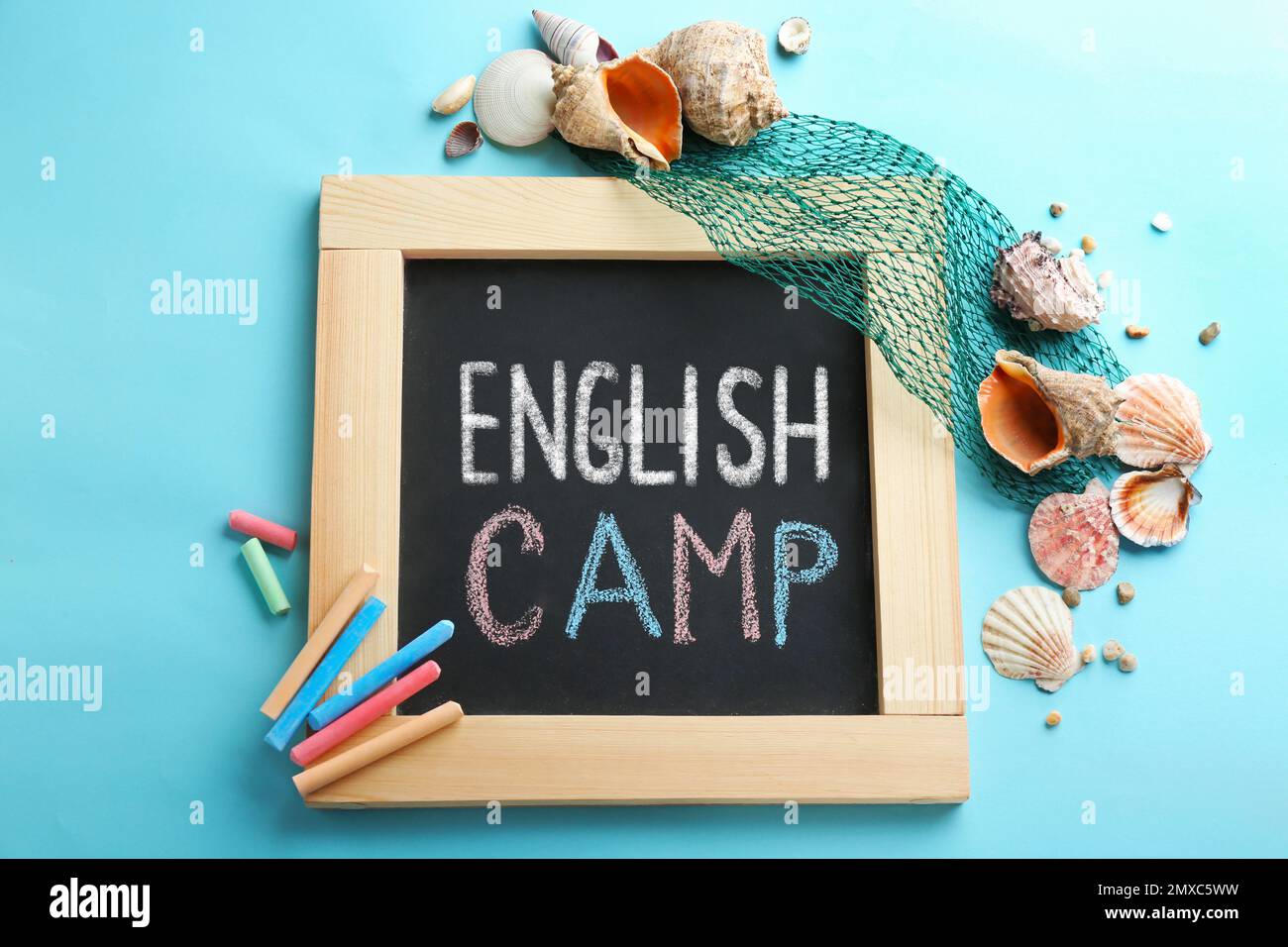 Blackboard with words ENGLISH CAMP, colorful chalk and shells on blue ...