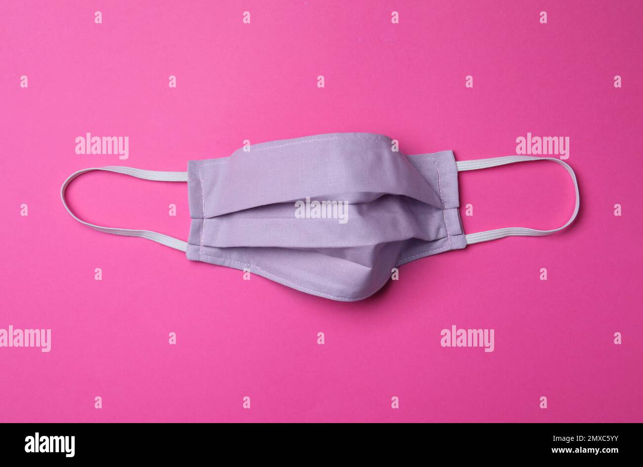 Homemade protective mask on pink background, top view. Sewing idea ...
