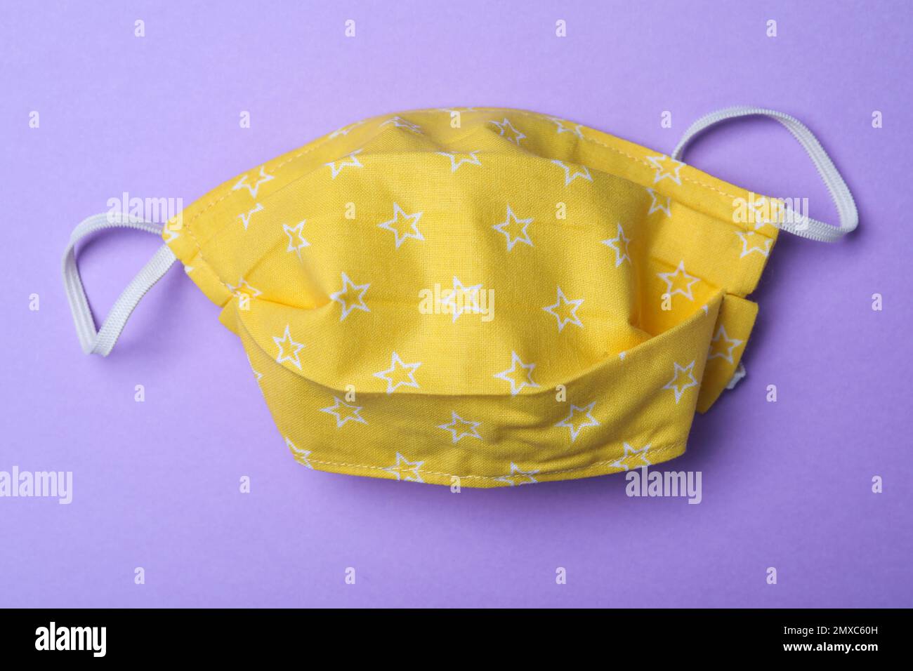 Homemade protective mask on violet background, top view. Sewing idea ...