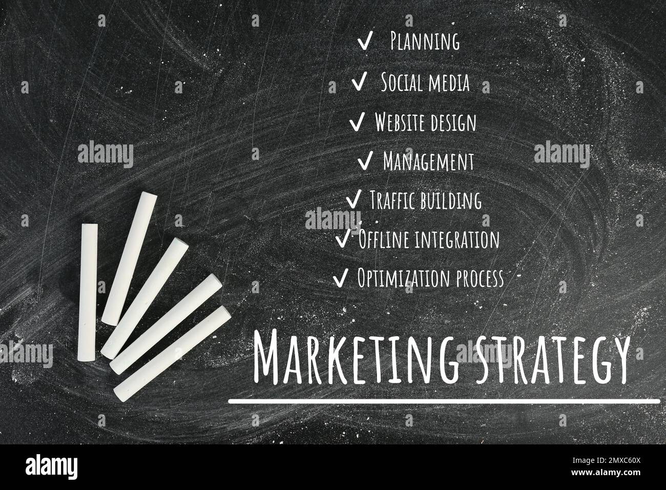 Blackboard with pieces of chalk and marketing strategy plan, top view ...