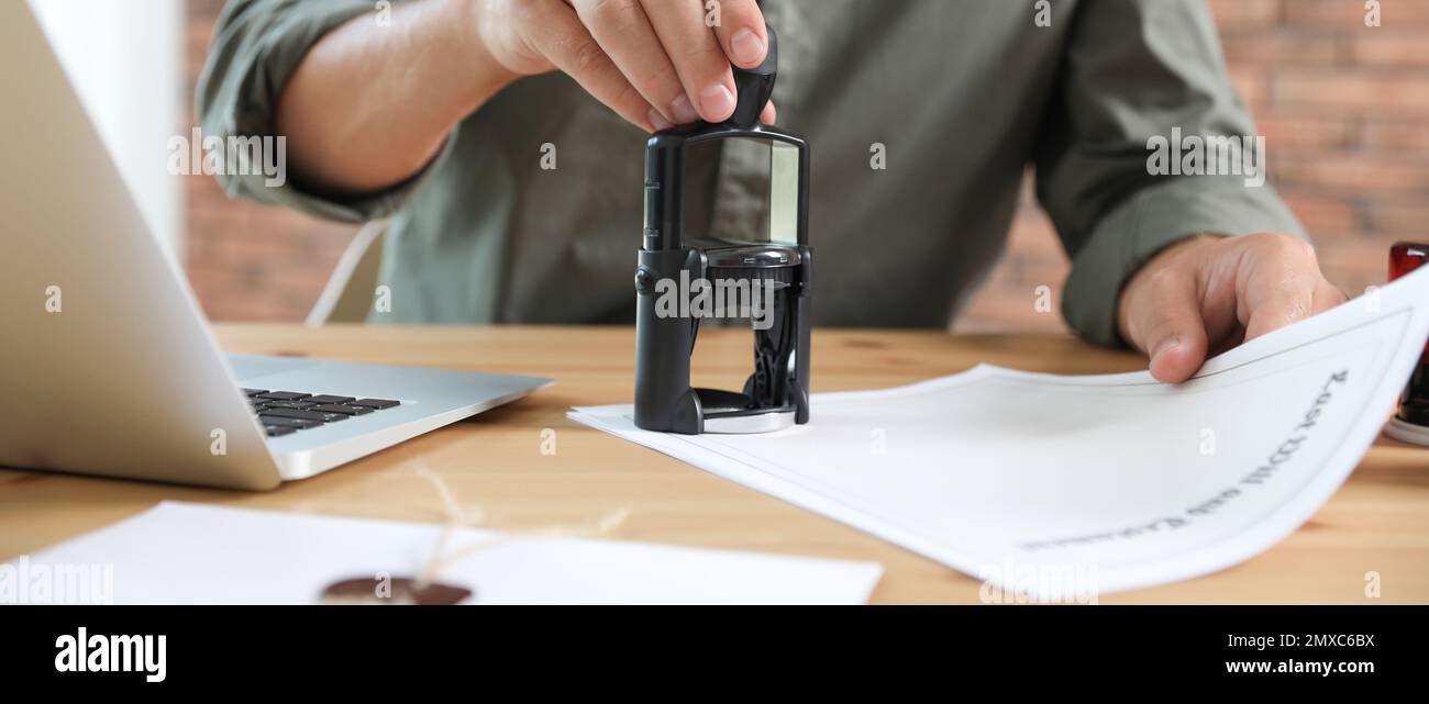 Notary stamping document at table in office, closeup. Banner design ...