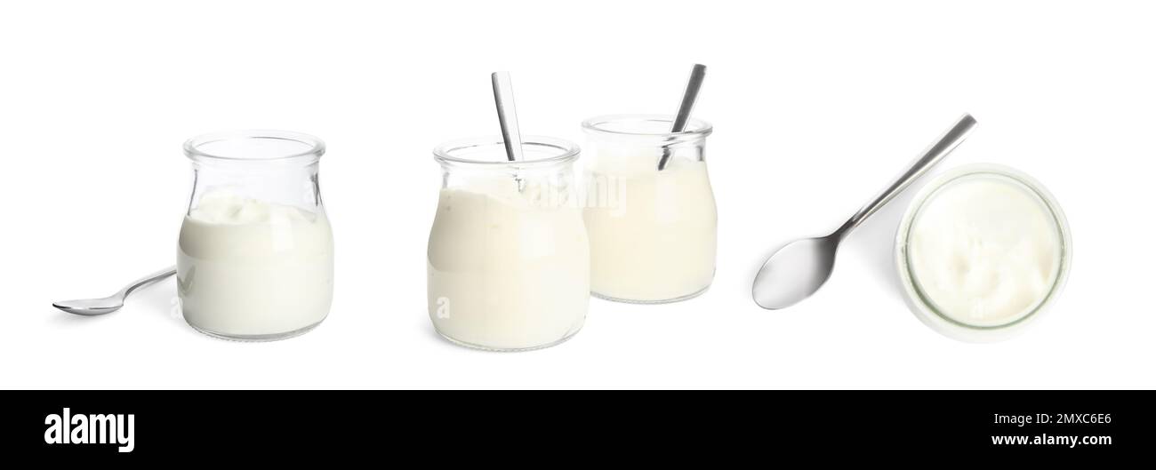 Set of delicious natural yogurt in glass jars with spoons on white ...