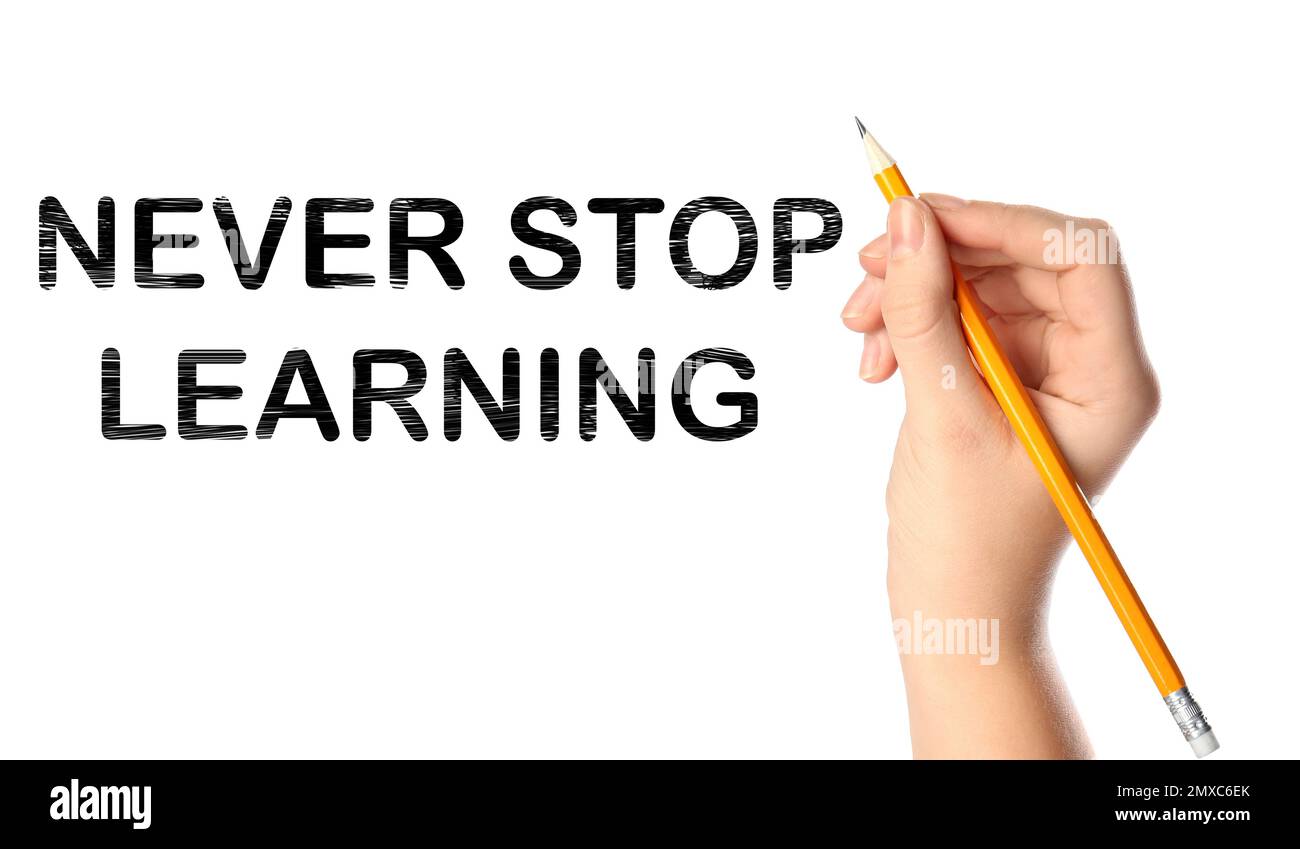 Woman writing phrase NEVER STOP LEARNING on white background, closeup ...