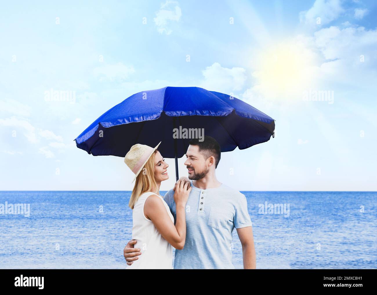 Happy romantic couple with umbrella for sun protection near sea Stock ...