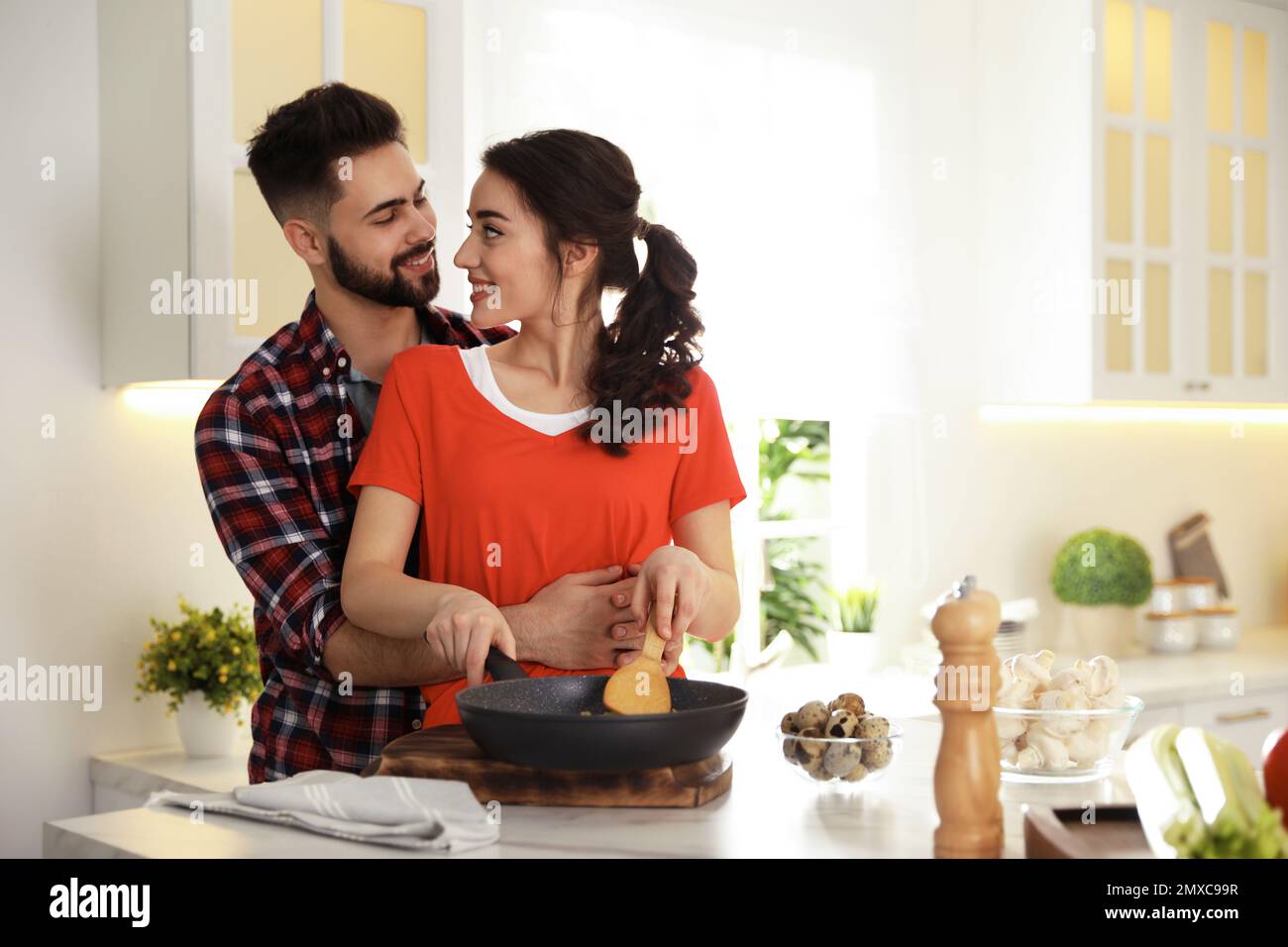 Lovely young couple cooking together in kitchen Stock Photo - Alamy