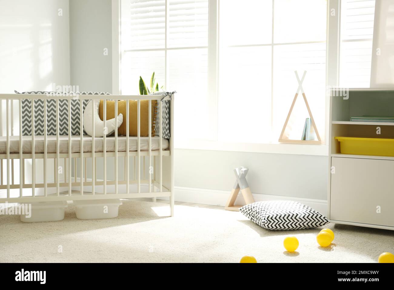 Cute baby room interior with crib and big window Stock Photo - Alamy