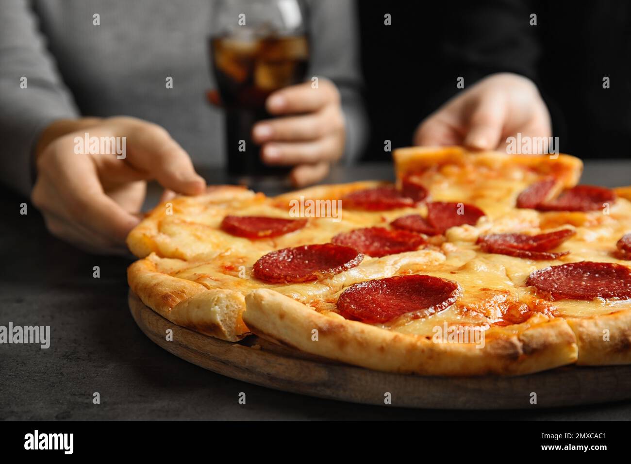 Women taking tasty pepperoni pizza at grey table, closeup Stock Photo ...