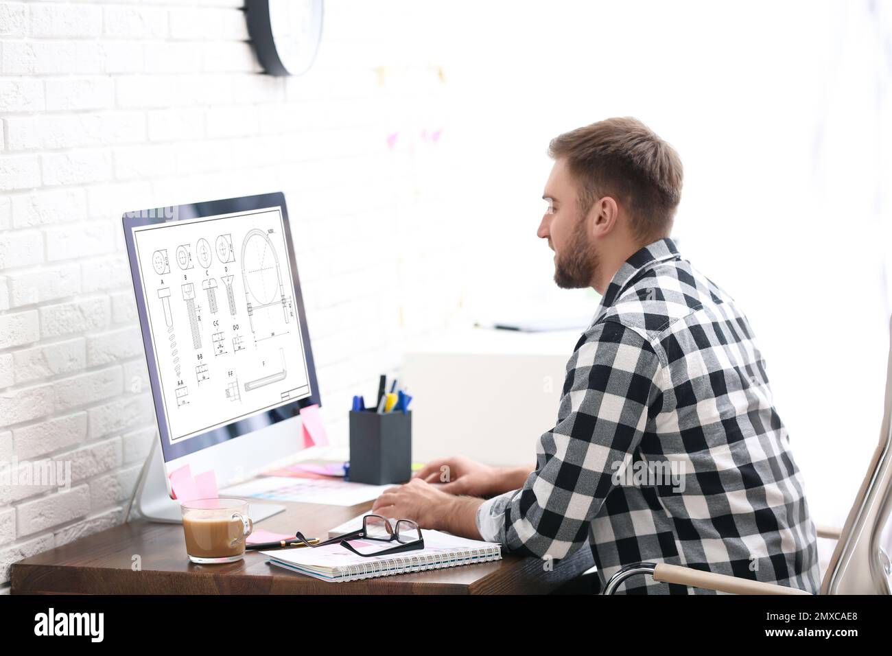 Male engineer working with technical drawing on computer indoors Stock ...