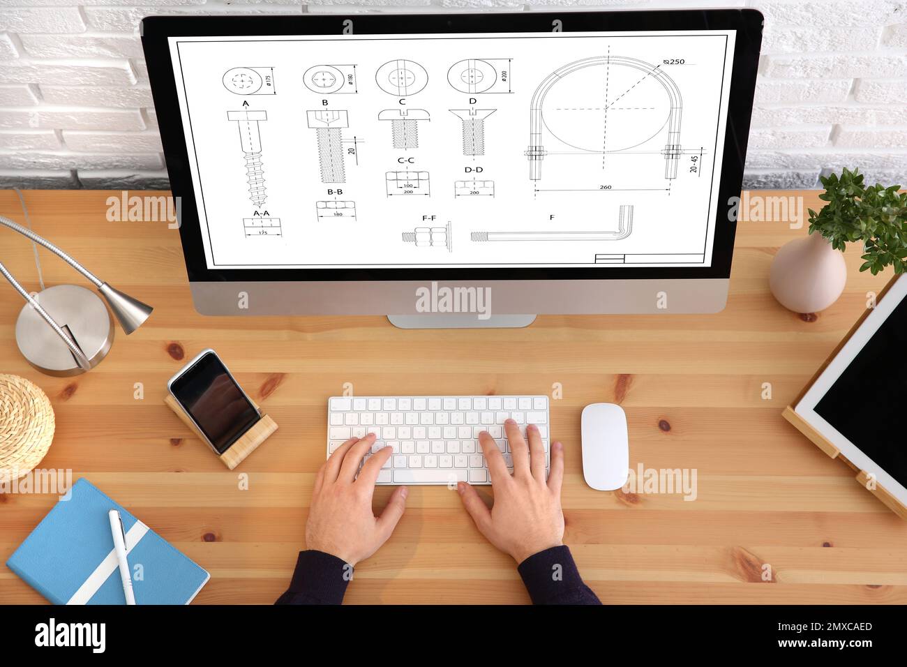 Male engineer working with technical drawing on computer indoors, top ...