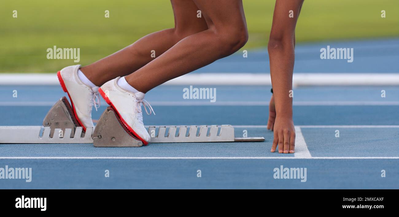 Woman in a starting block on an athletic field Stock Photo - Alamy