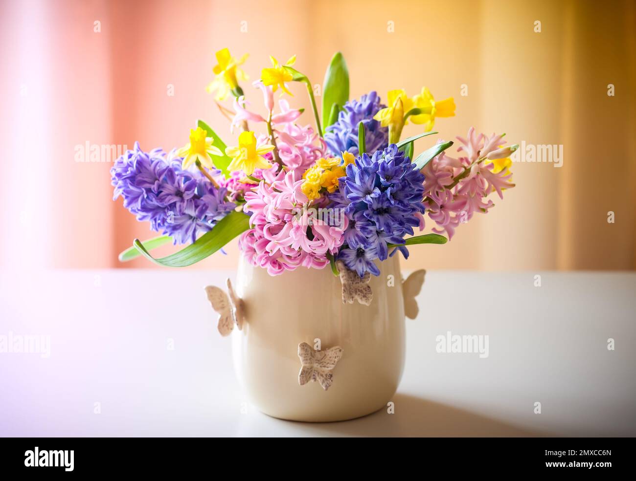Fresh beautiful spring flowers in vase on table. Easter decoration for ...