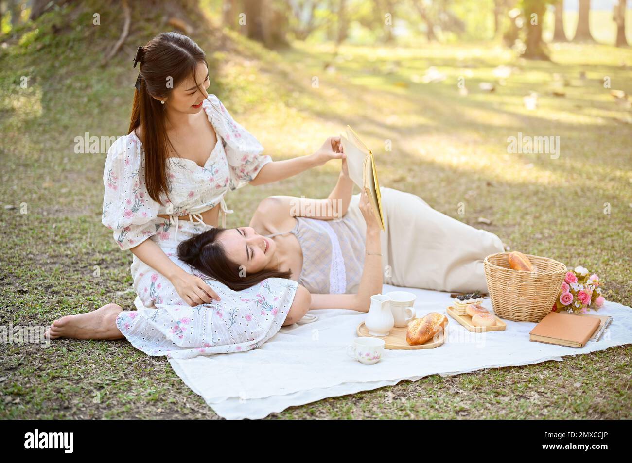 Two attractive and happy millennial Asian women in beautiful dresses ...