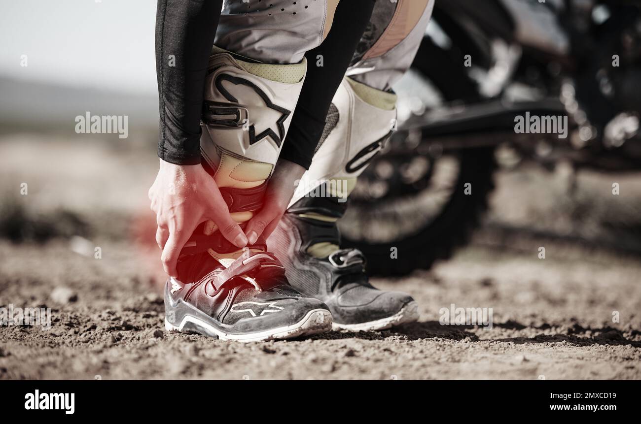 Ankle, injury and motorcycle with the hands of a man holding his joint ...