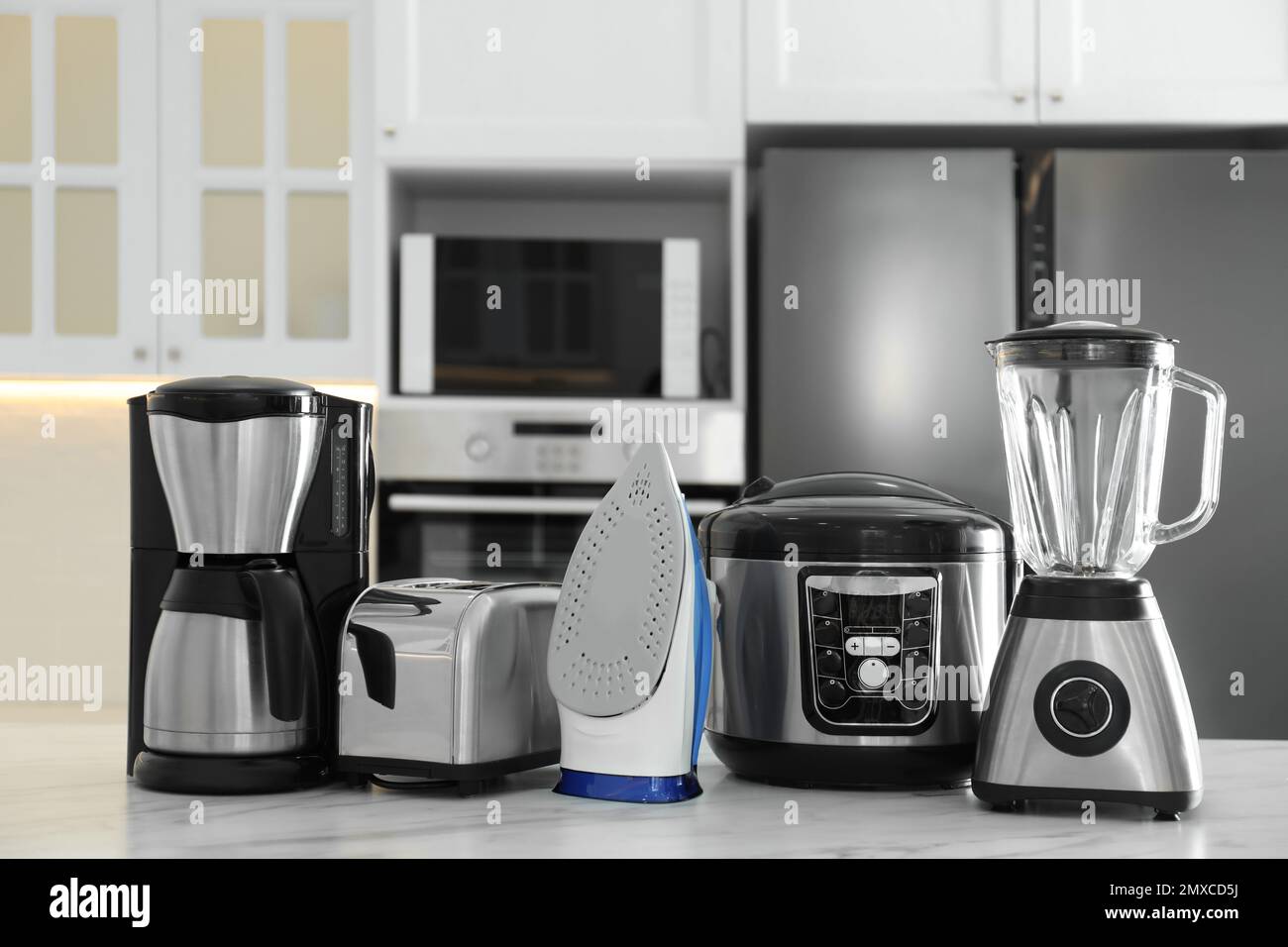 Set of modern home appliances on white marble table in kitchen Stock ...