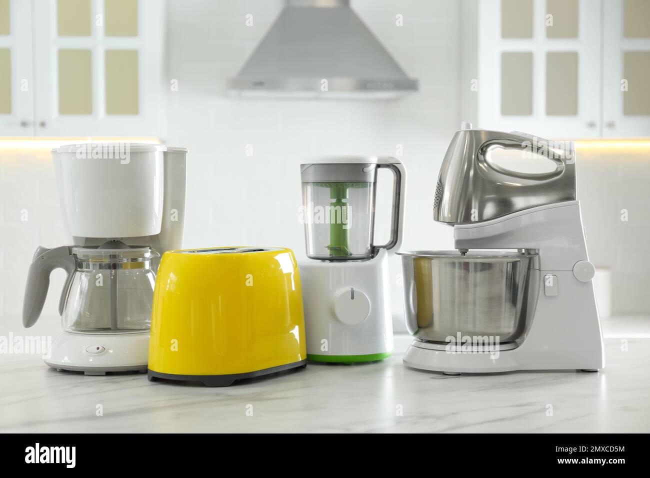Set of modern home appliances on white marble table in kitchen Stock ...