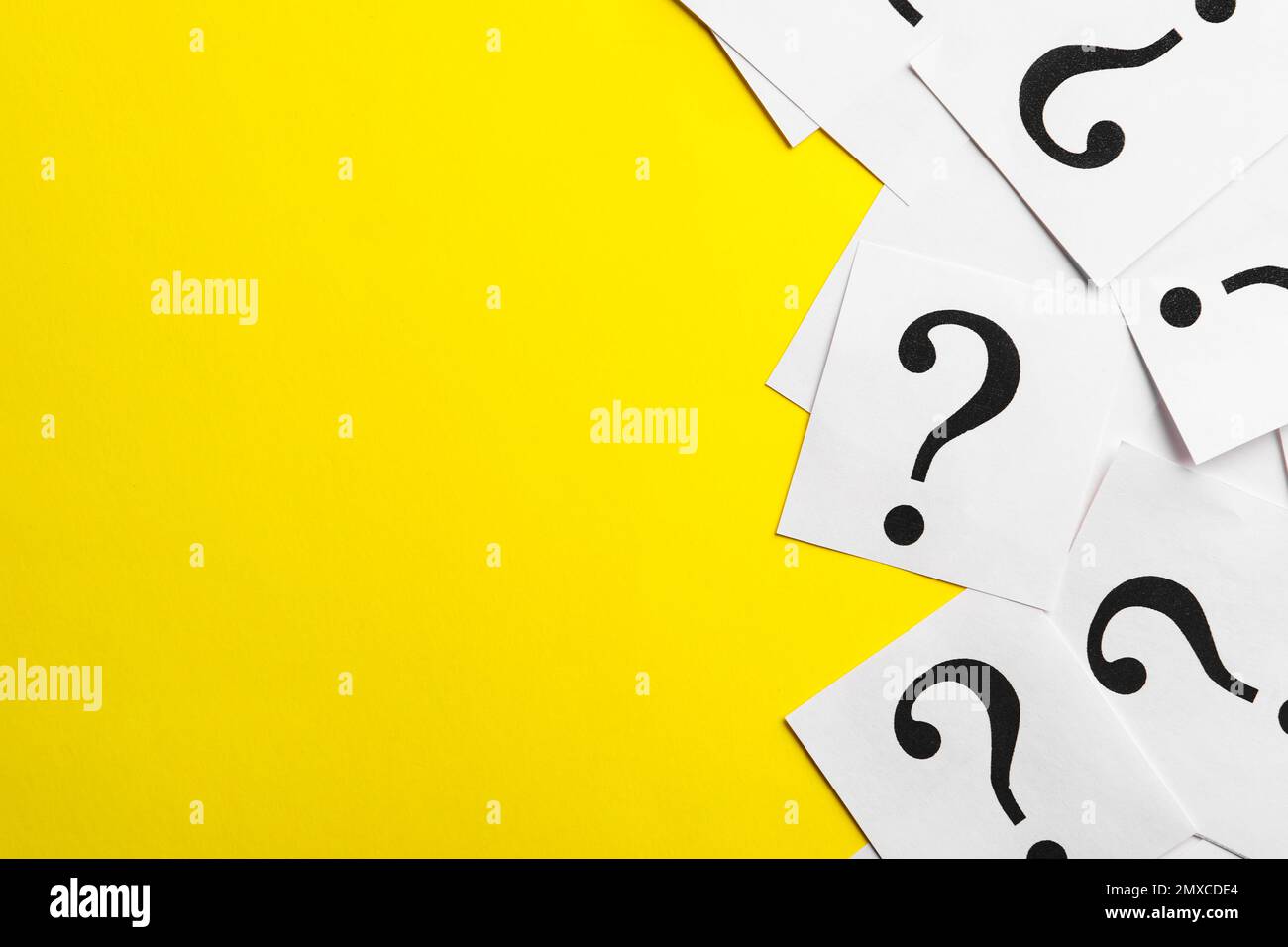 Paper notes with question marks on yellow background, flat lay. Space ...