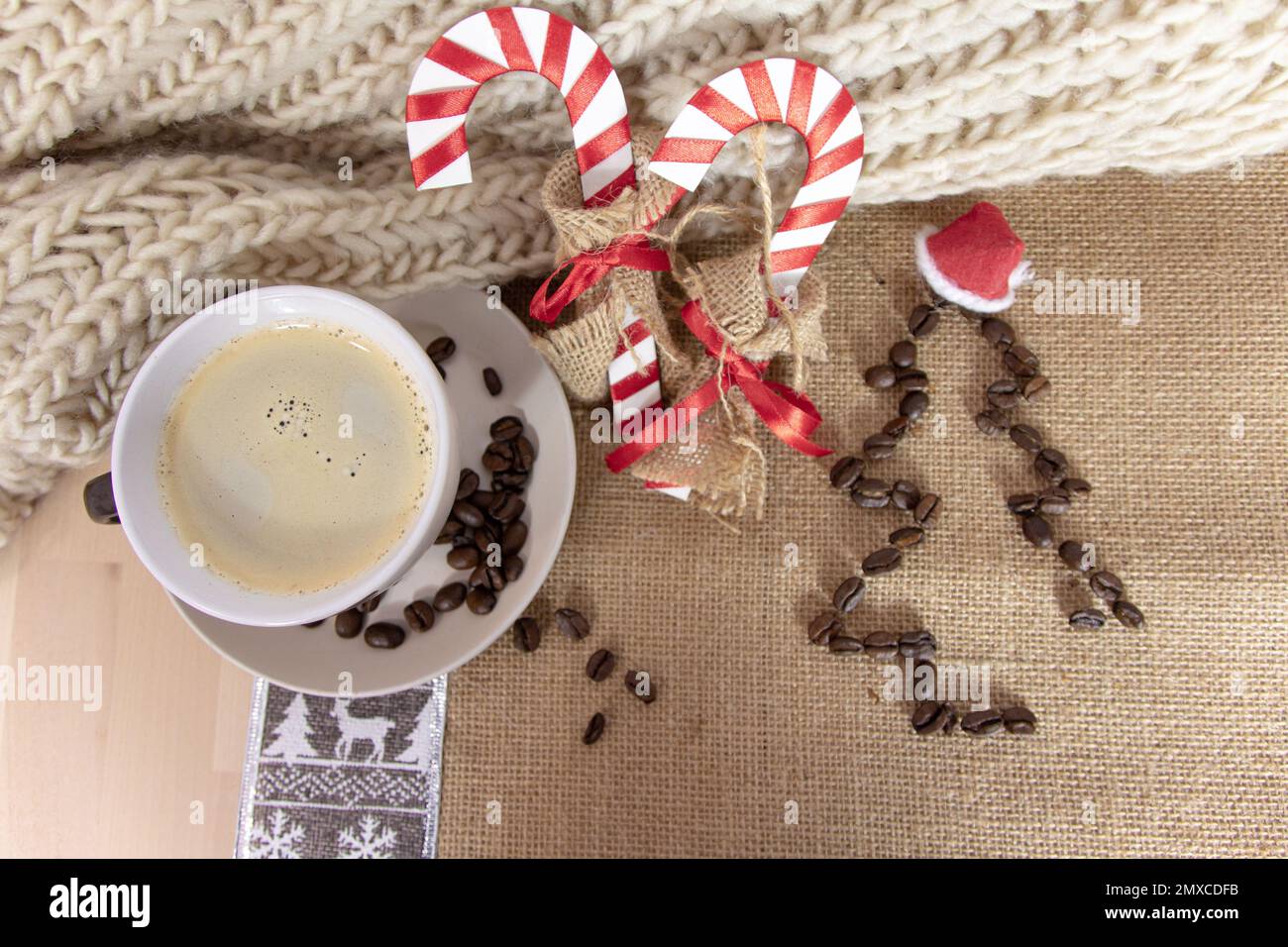 Christmas table scene with cup of coffee, two decorative candy canes ...