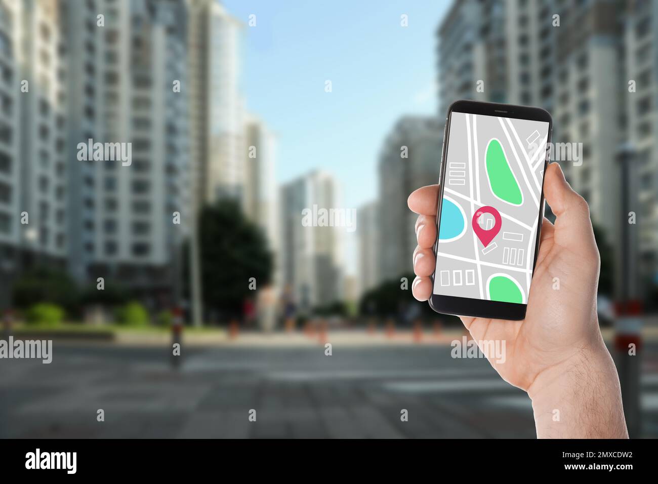 Man searching location with smartphone in city, closeup. Space for text ...