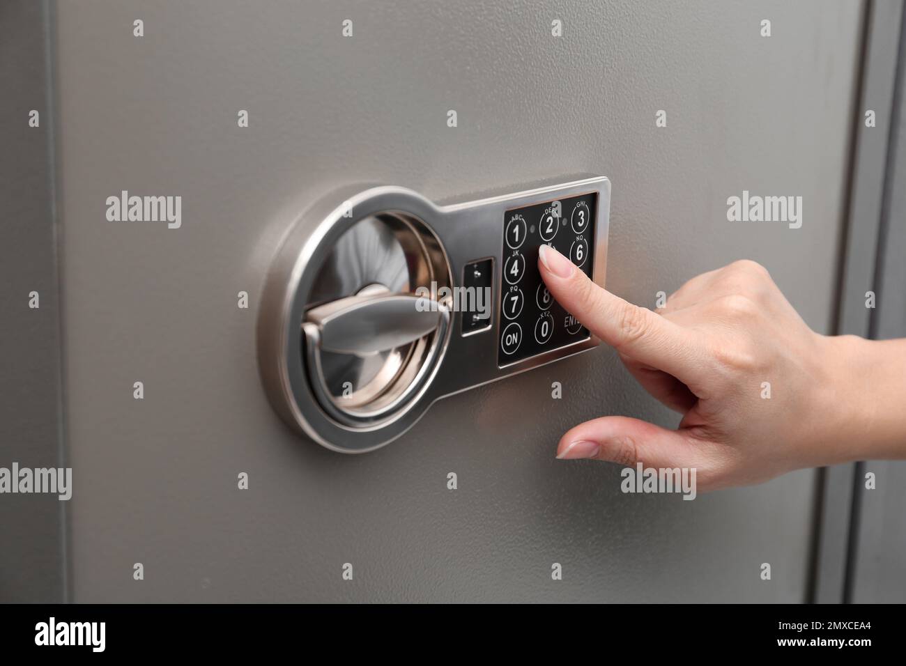 Woman entering code on keypad of modern safe, closeup Stock Photo - Alamy