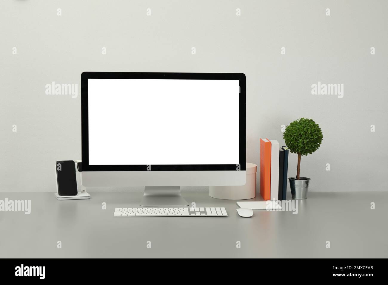 Modern workplace with computer, charging devices and decor elements ...